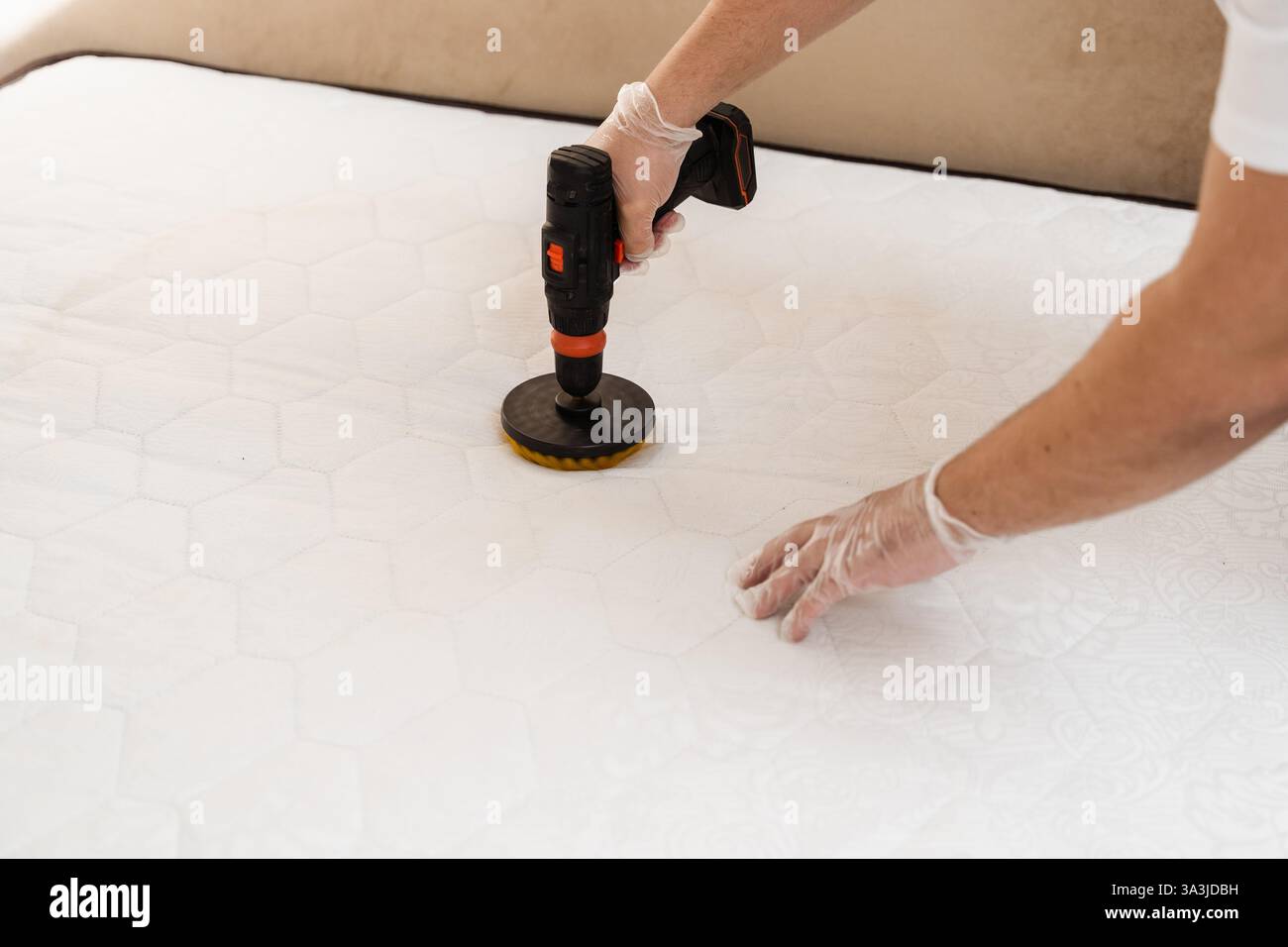 Smearing detergent on white mattress using drill with brush for dry ...