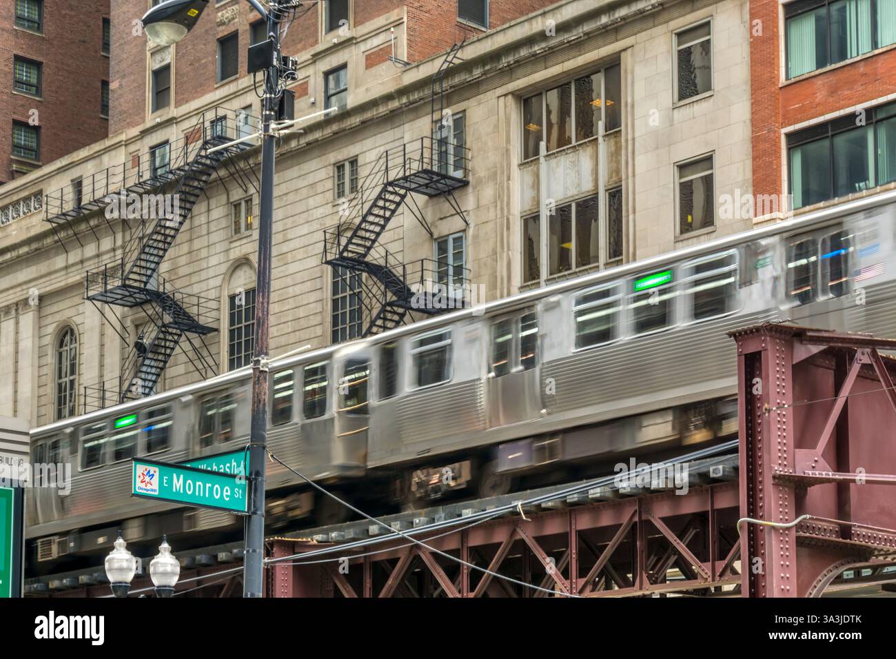 An El train, motion blurred, speeds past East Monroe Street, Chicago ...