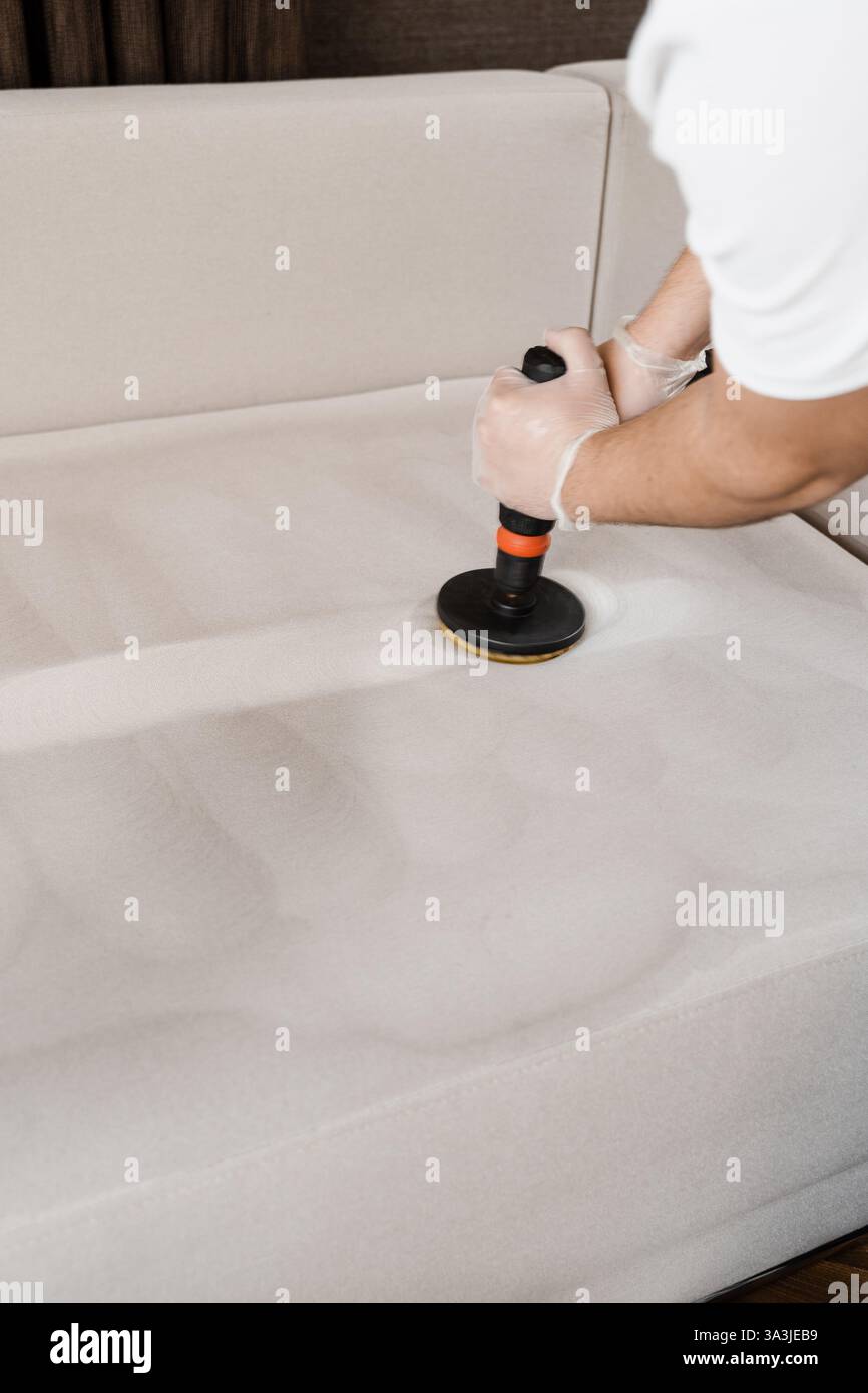 Smearing detergent on couch using drill with brush for dry cleaning ...