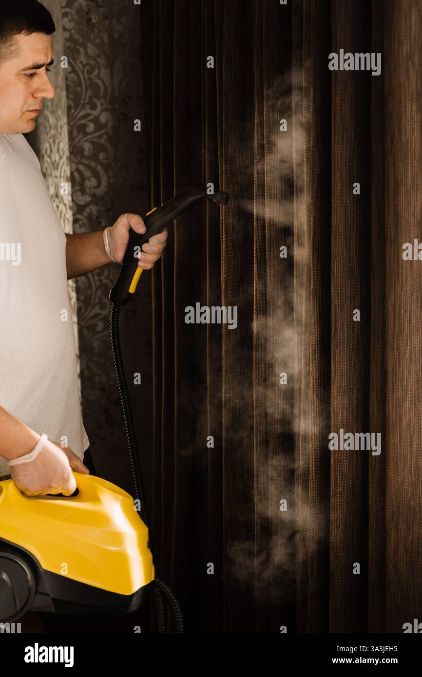 Cleaner is steaming the curtains using a professional steam machine ...