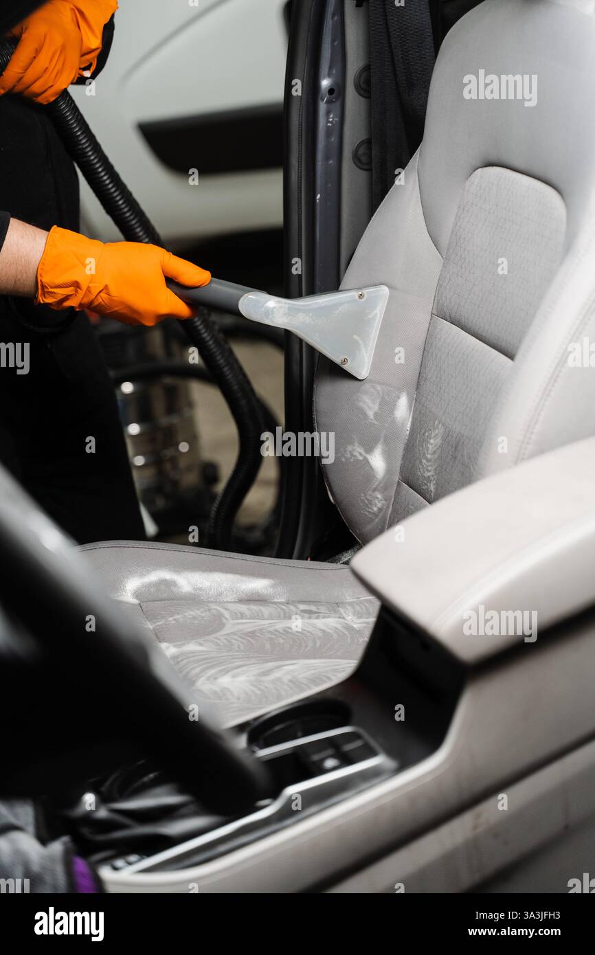 Car cleaner is extracting dirt from car seat using dry cleaning ...