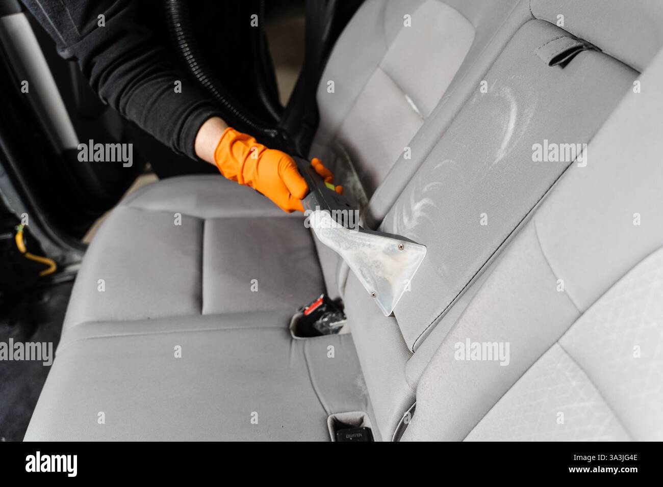 Car cleaner is extracting dirt from car seat using dry cleaning ...