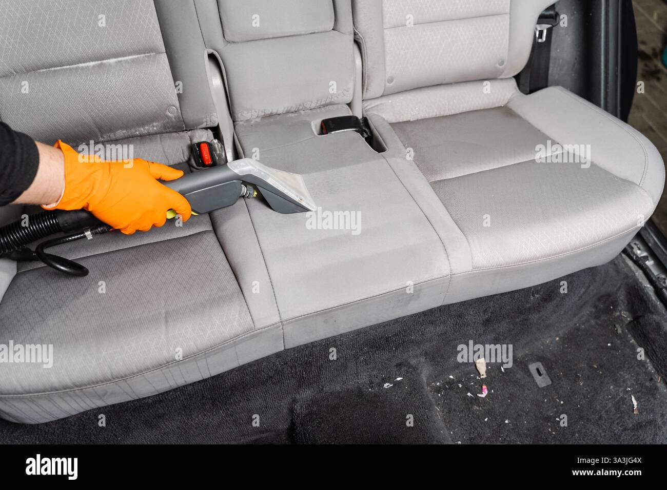 Car cleaner is extracting dirt from car seat using dry cleaning ...