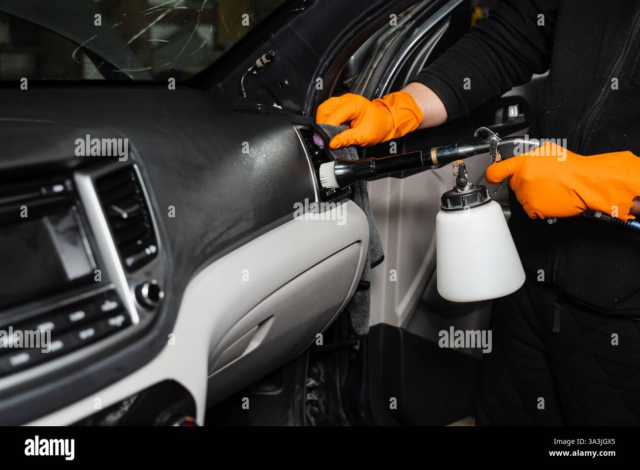 Cleaner is washing air system and spraying detergent from tornador gun. Car detailing with ...