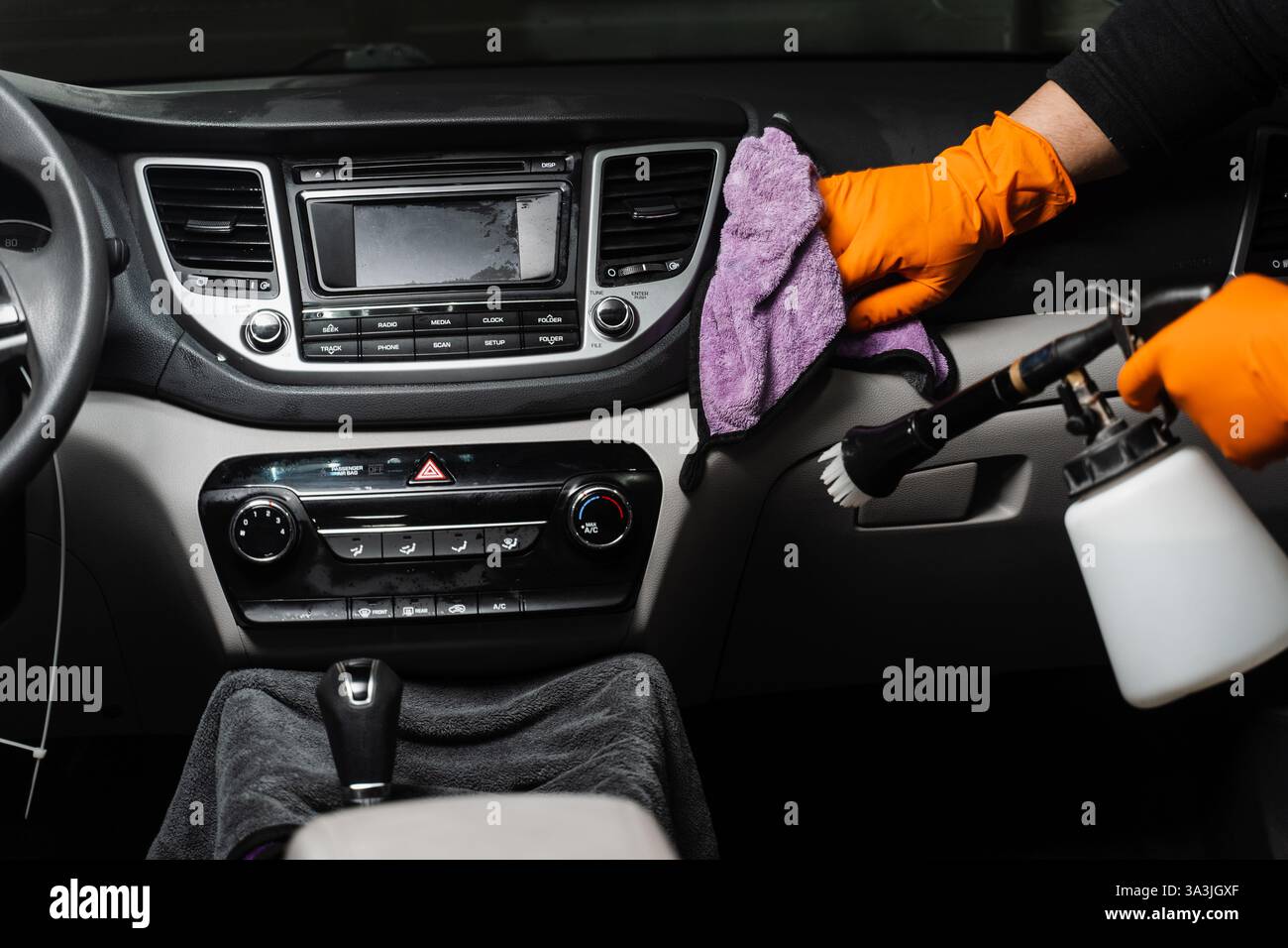 Car detailing with tornador cleaning gun with high pressure air pulse. Cleaner is washing air ...