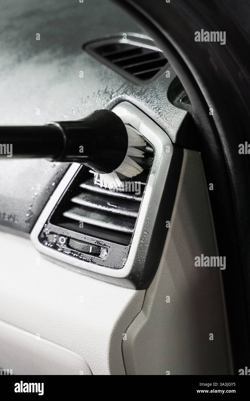 Close-up car detailing with tornador cleaning gun with high pressure air pulse. Cleaner is ...