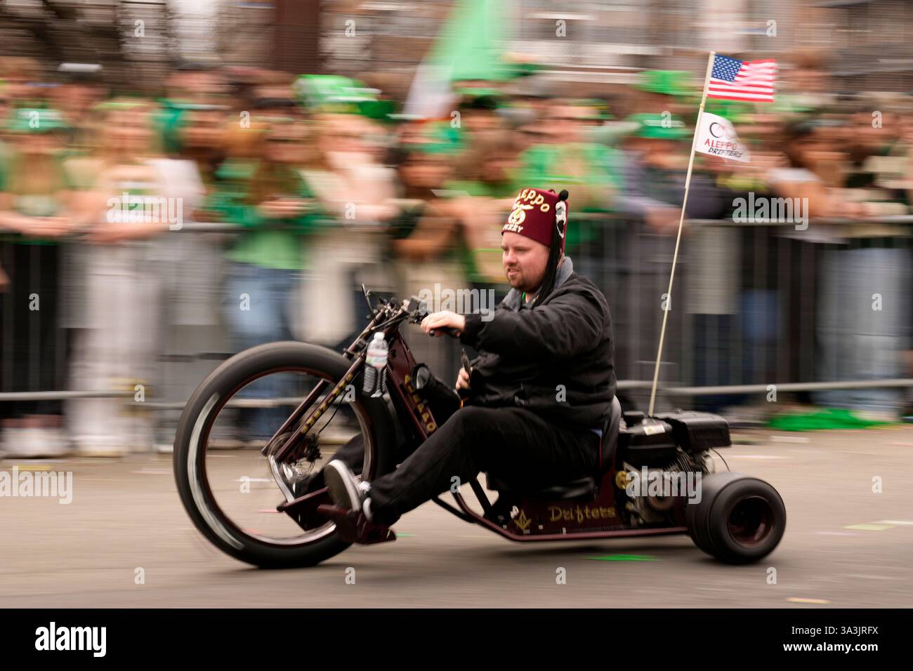 A Shriner motors by the crowd during the St. Patrick's Day parade ...