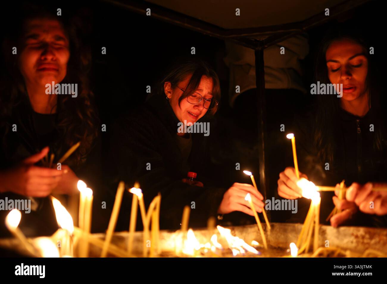 Girls cry as they light candles in the town of Kocani, North Macedonia ...