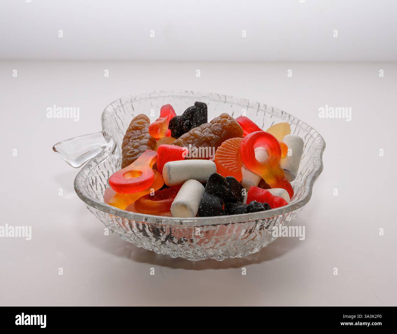 A variety of vibrant candies, including gummy shapes and licorice ...