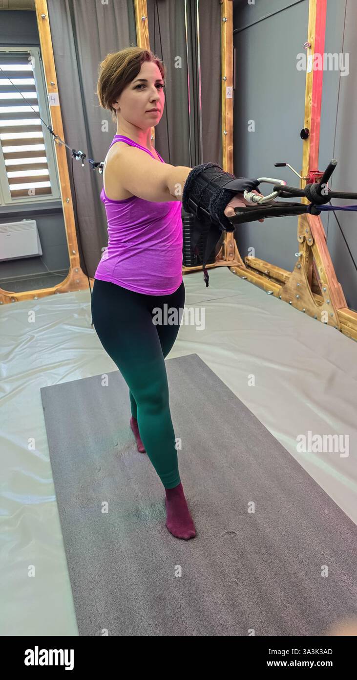 Sportswoman performing cable row exercise using resistance band ...