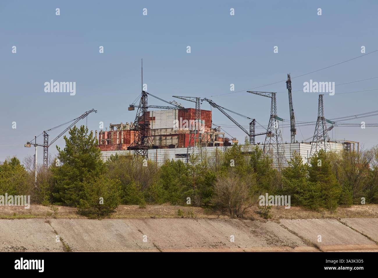 View of the Chernobyl Nuclear Power Plant with cranes and power lines ...
