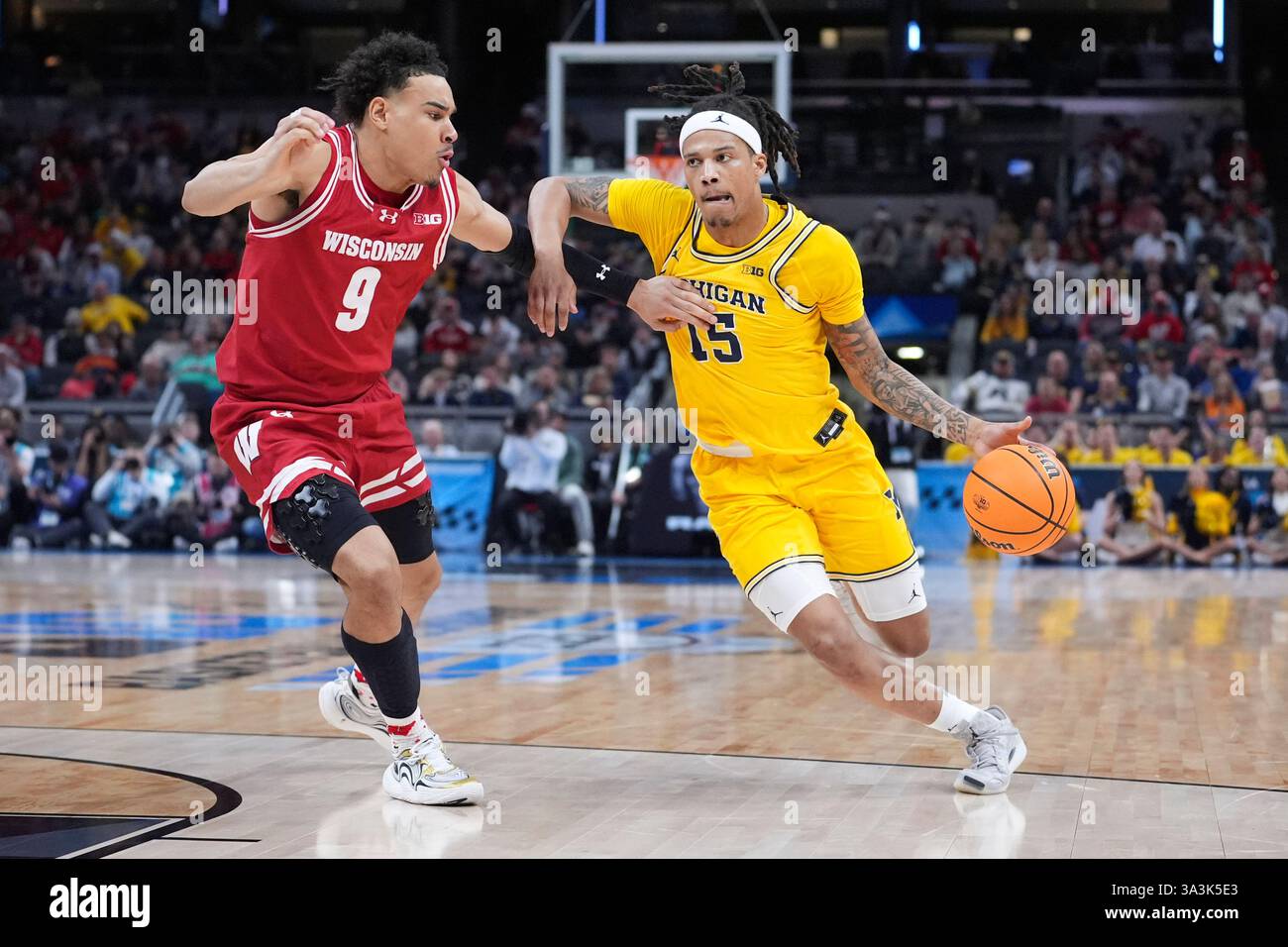 Michigan guard Rubin Jones (15) drives on Wisconsin guard John Tonje (9 ...