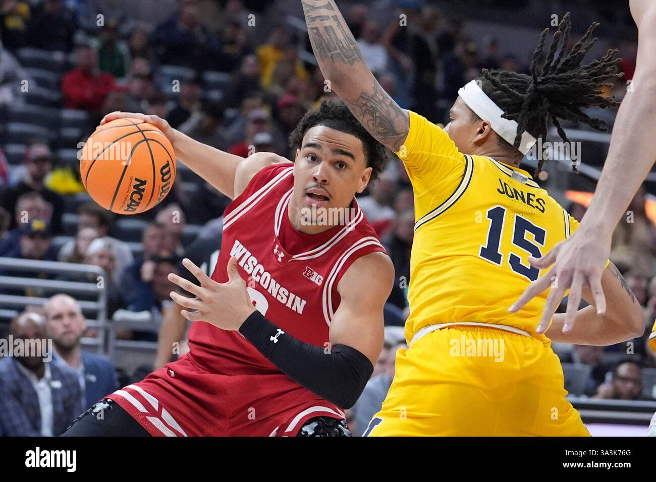 Wisconsin guard John Tonje (9) drives on Michigan guard Rubin Jones (15 ...