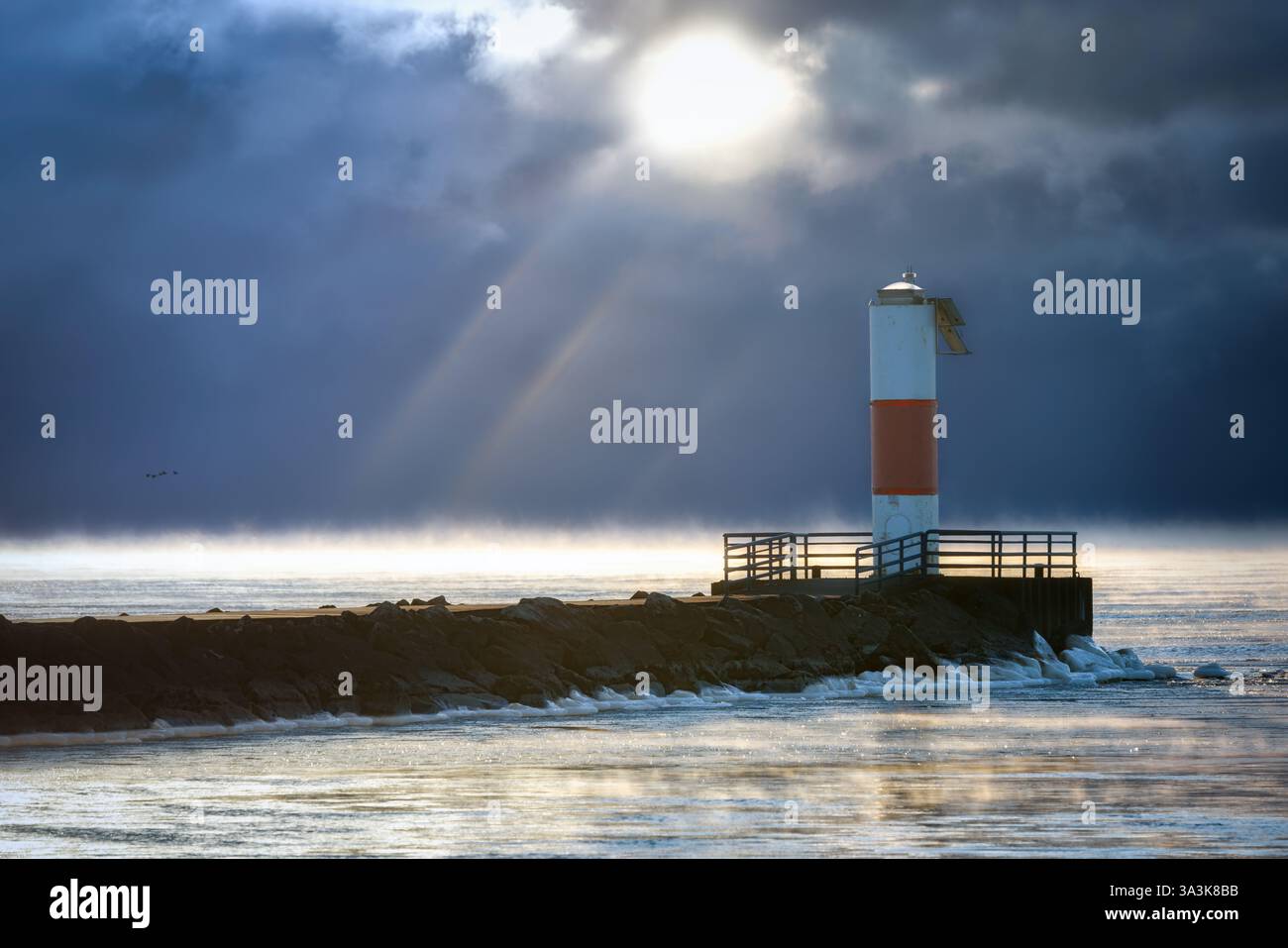 Steam rises off Lake Michigan behind the pier light in Two Rivers ...