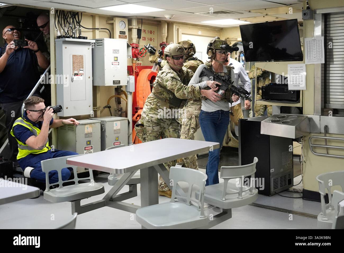 Homeland Security Secretary Kristi Noem, right, participates in a ship ...