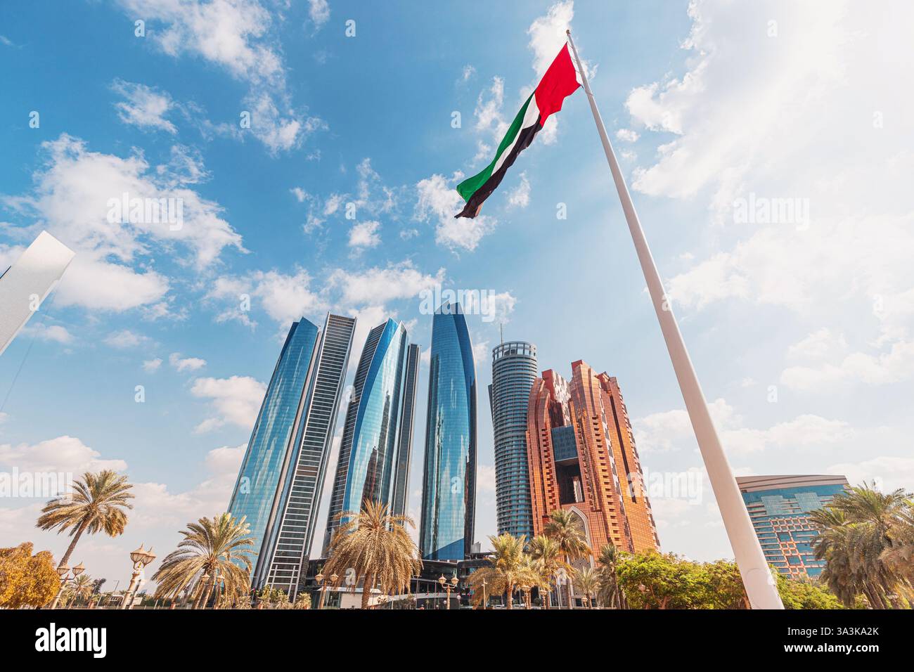 Low angle view of the UAE flag waving with modern skyscrapers on the ...