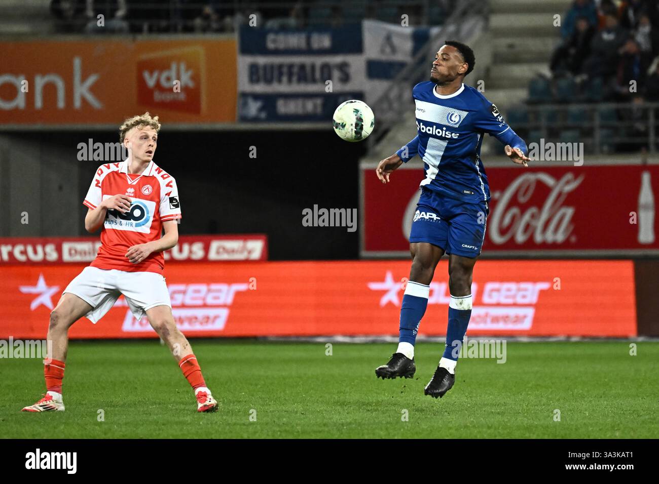 Kortrijk's Dion De Neve and Gent's Samuel Kotto fight for the ball ...