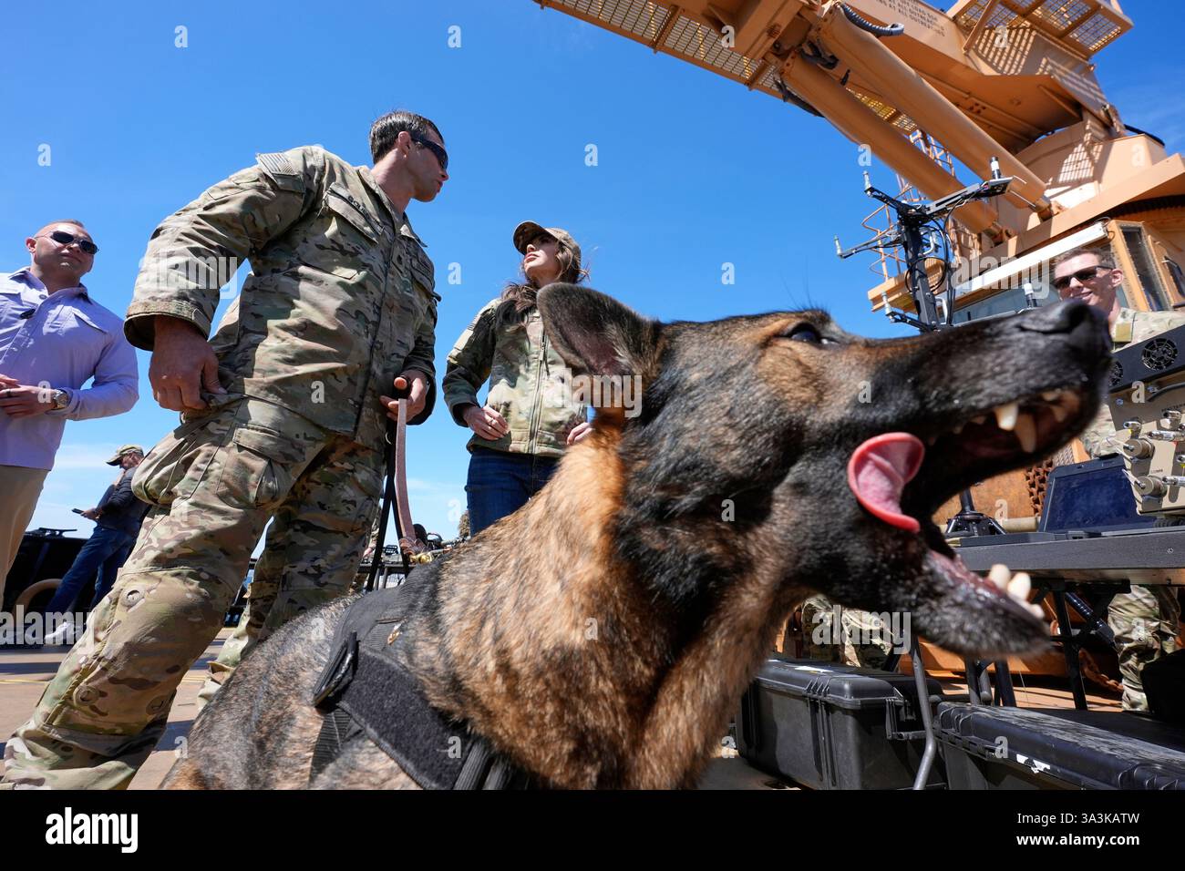 Homeland Security Secretary Kristi Noem, in background center, listens ...