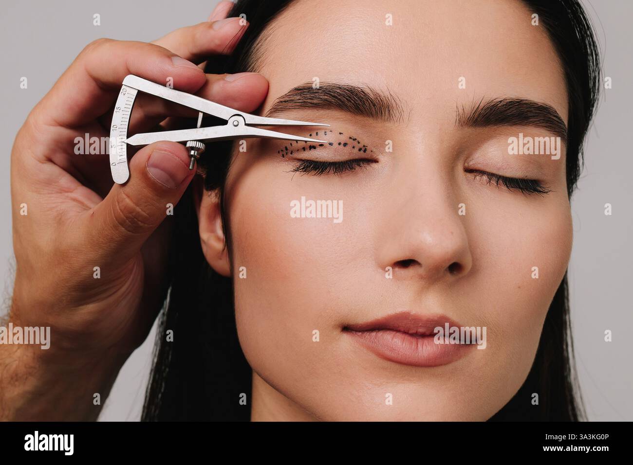 Upper blepharoplasty. Plastic surgeon is measuring surgical distance ...