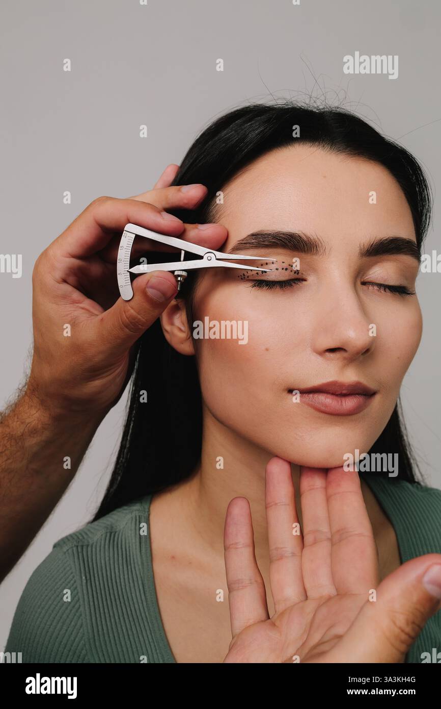 Upper blepharoplasty. Plastic surgeon is measuring surgical distance ...