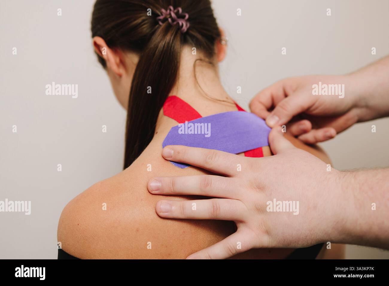 Medical tape. Doctor is applying bright kinesiology tape on athlete to ...