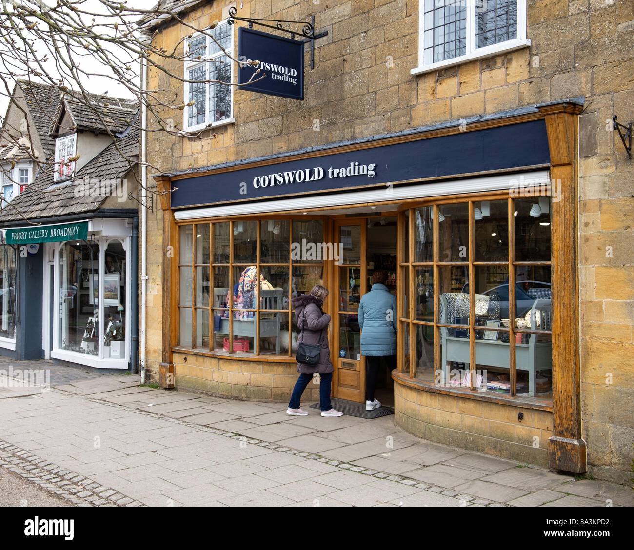 People entering the Cotswold trading shop with a stone facade in the ...