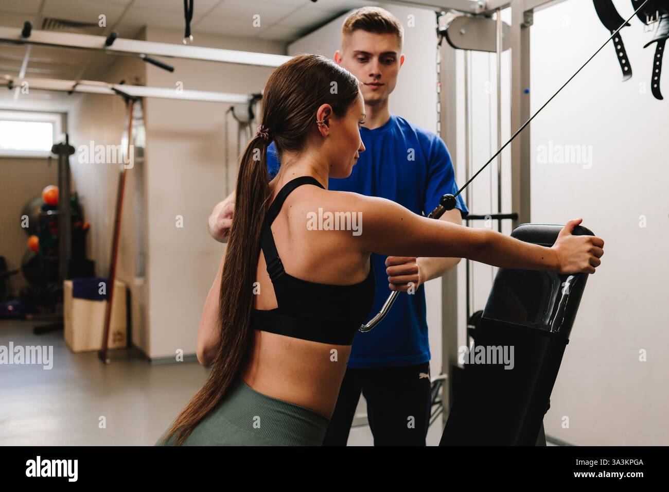 Assisted therapeutic gymnastics to strengthen muscles and rehabilitate injury. Female patient is ...