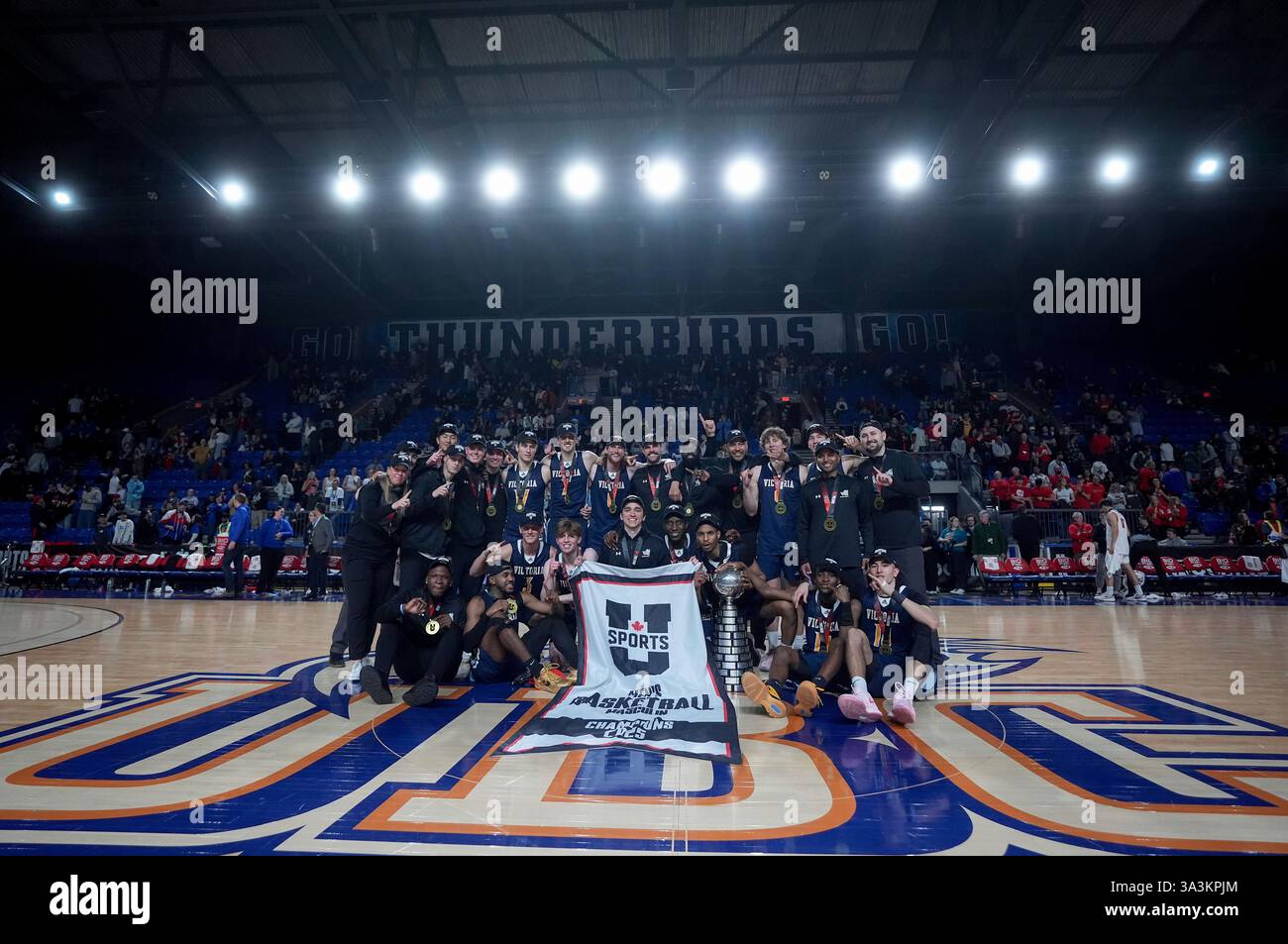 University of Victoria players celebrate with the trophy and banner ...