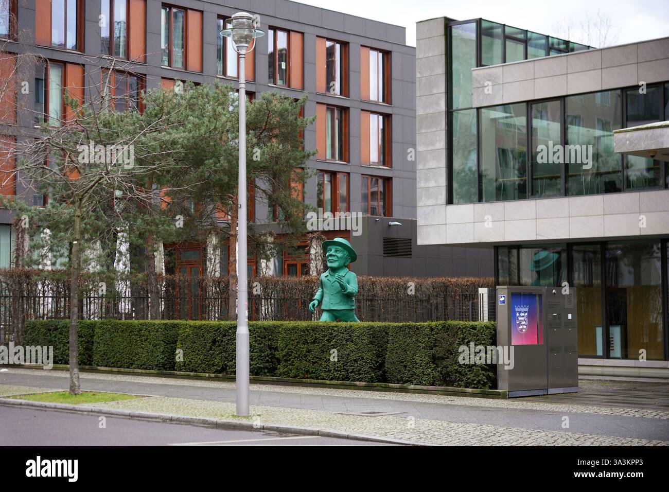 Berlin, Germany 02.13.2025 Green Ampelmann statue in modern urban ...