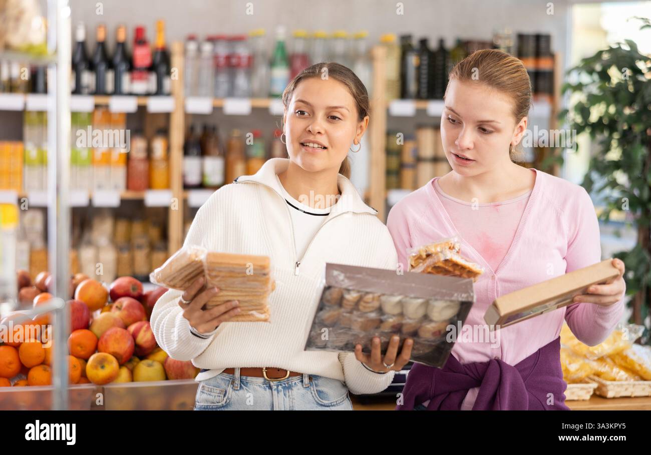 Two women choose sweets in supermarket Stock Photo - Alamy