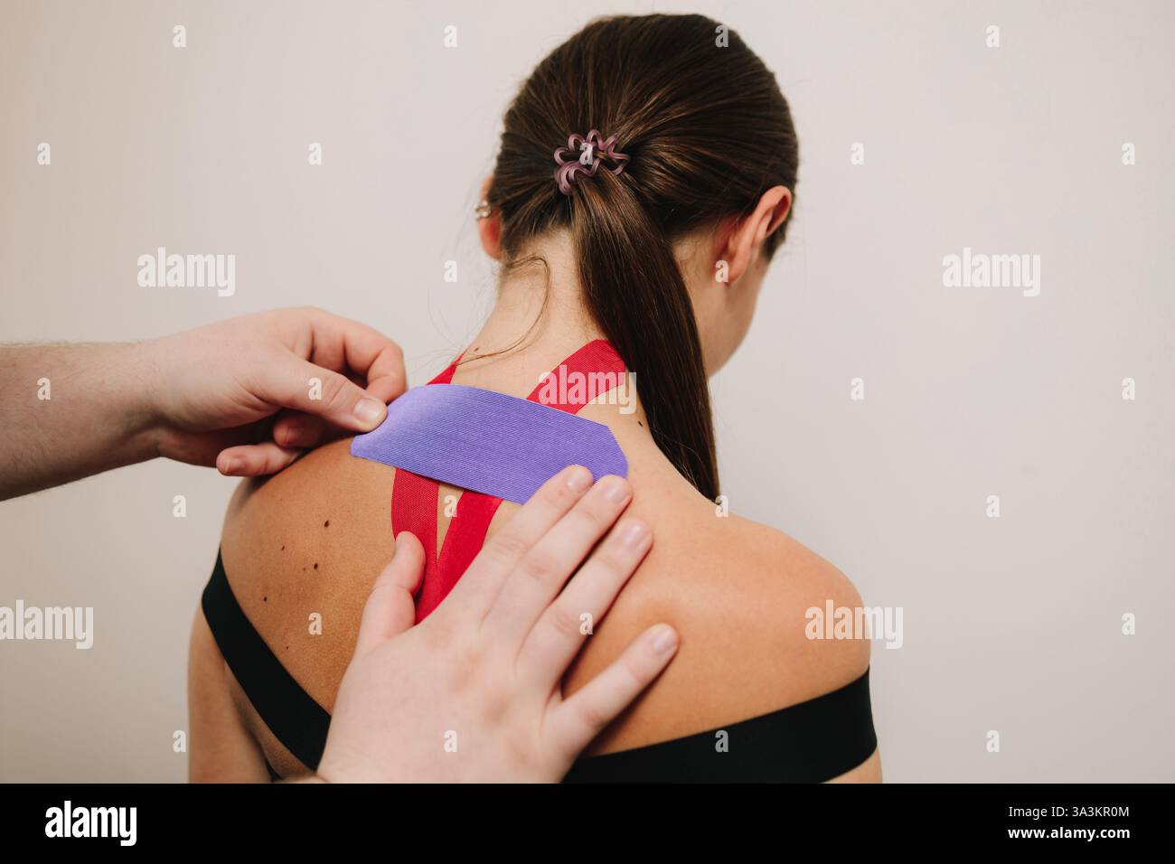 Medical tape. Doctor is applying bright kinesiology tape on athlete to ...