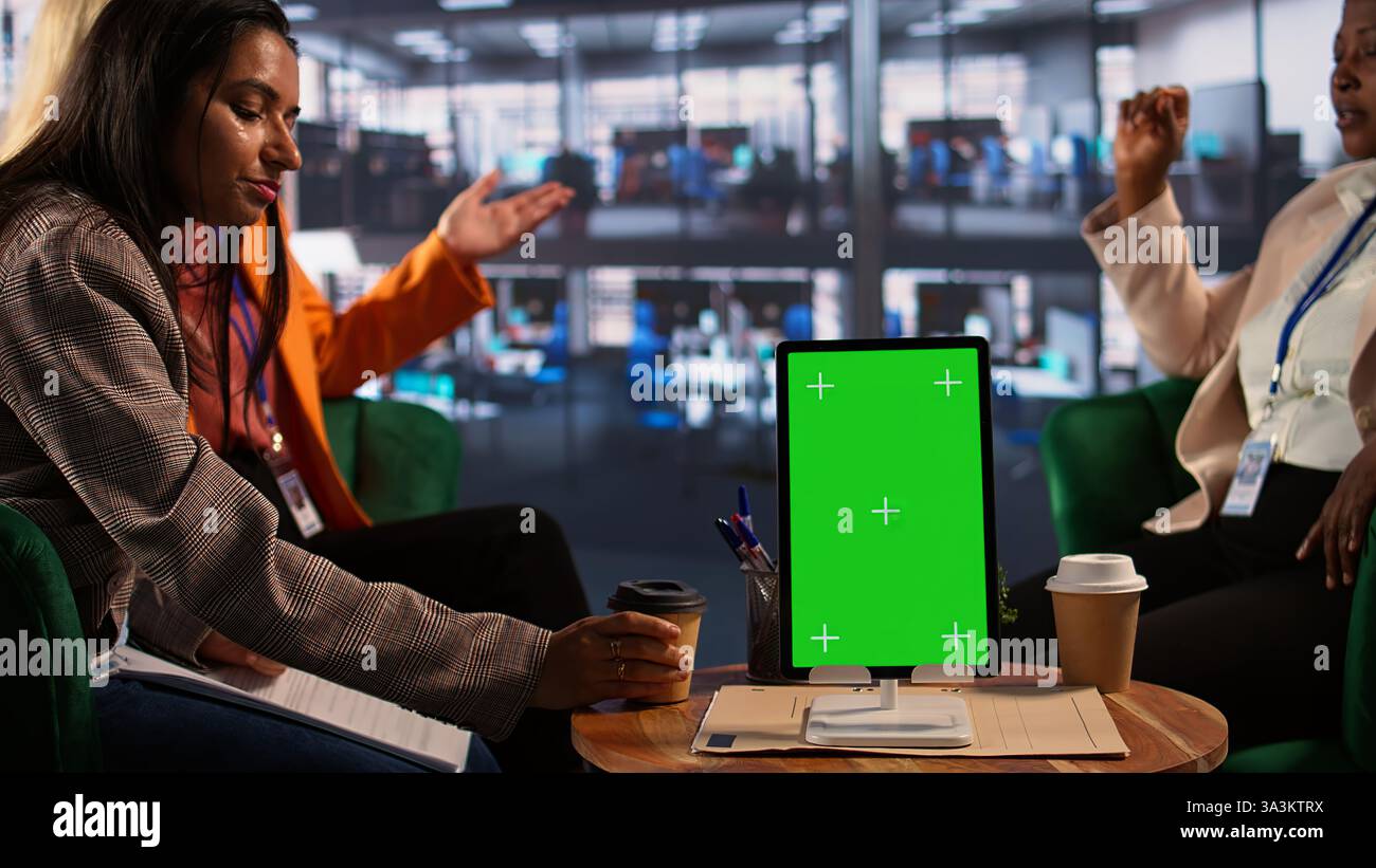 Diverse group of women working together next to chroma key screen ...
