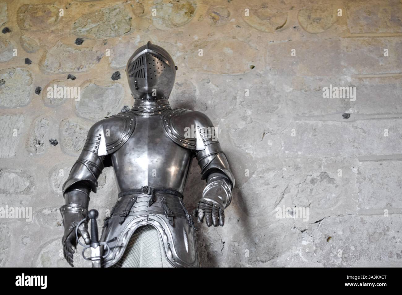 Front view medieval shiny armor with details and white stone wall in ...