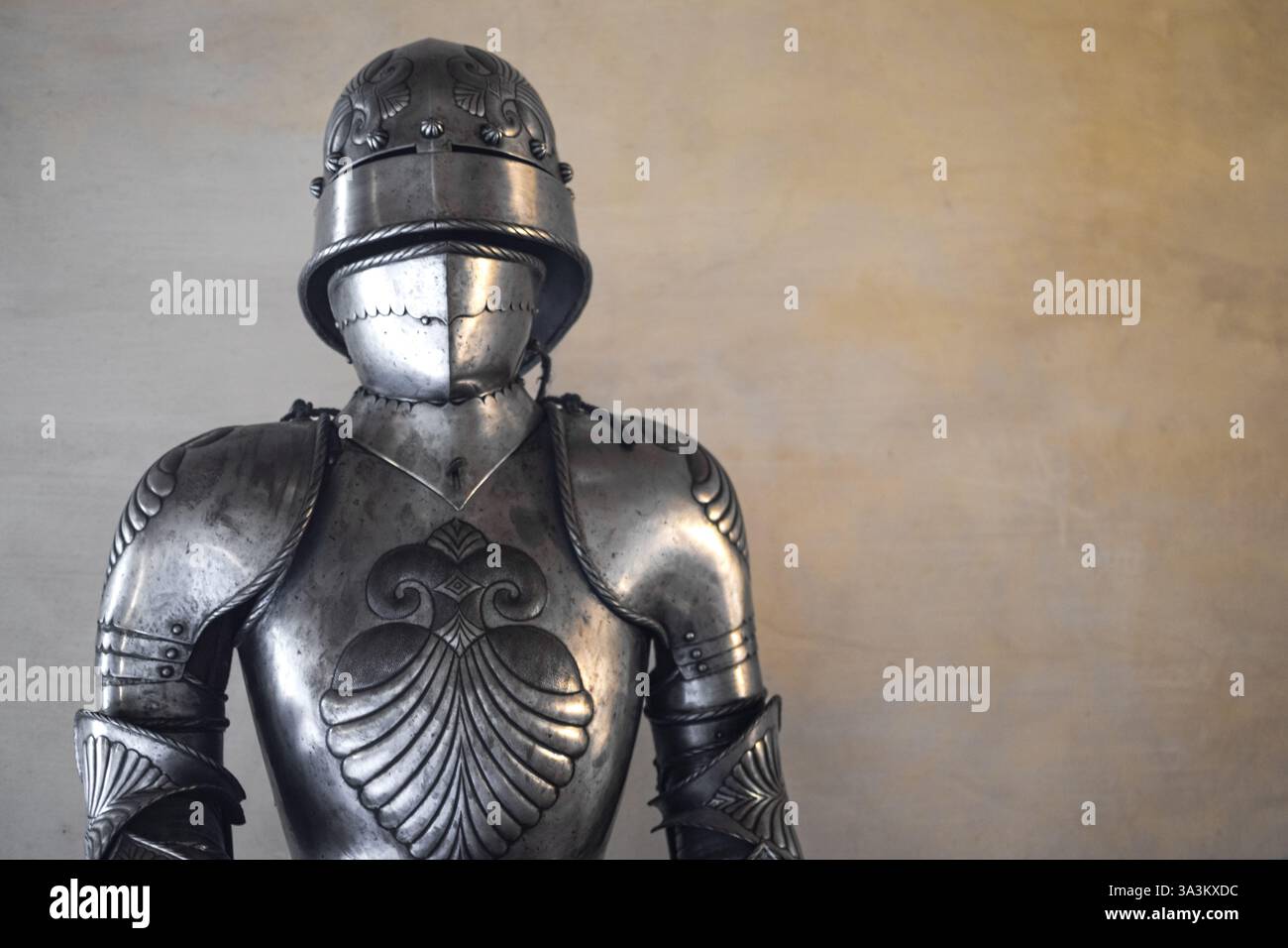 Front view of medieval shiny armor with details and white wall in ...