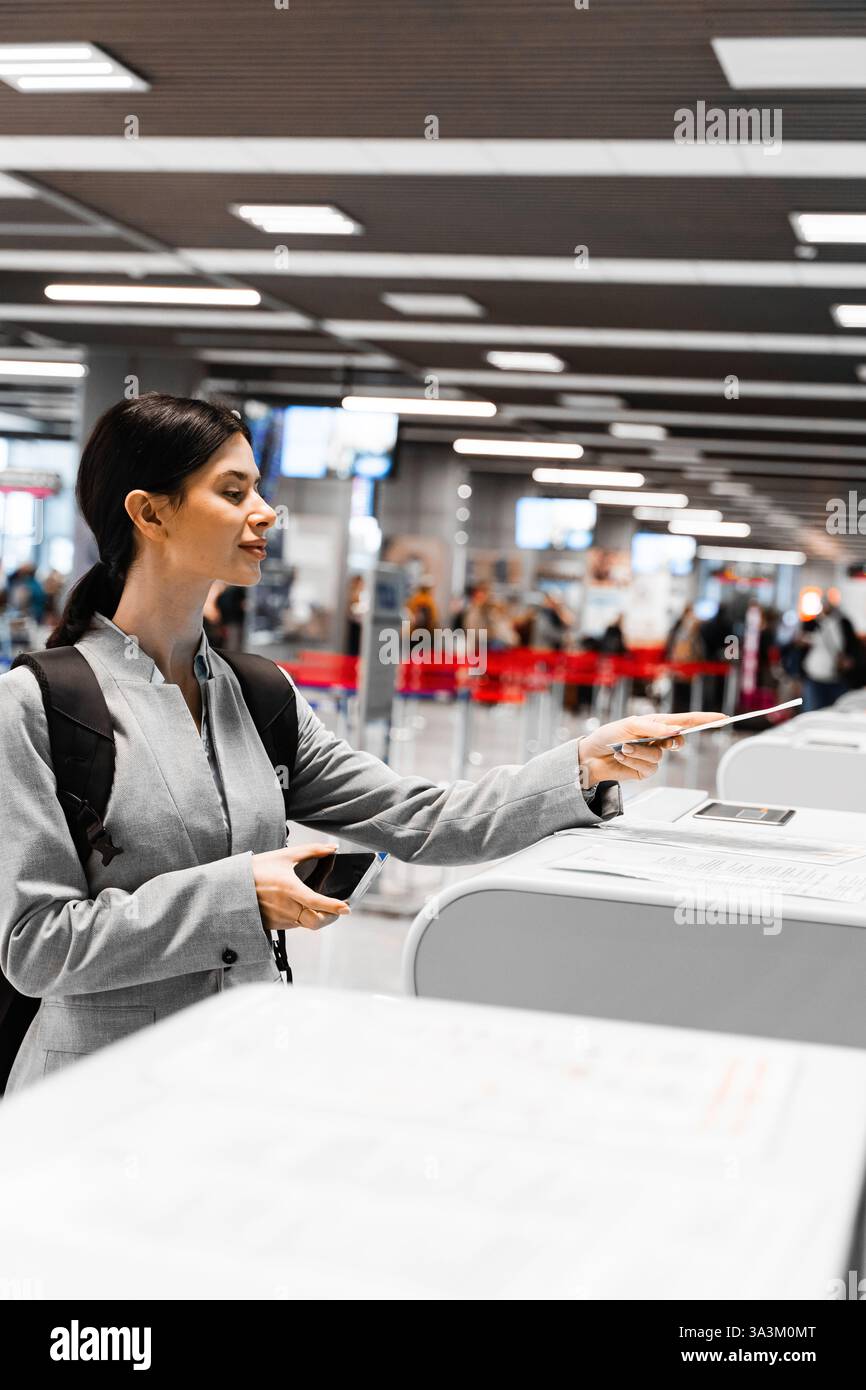 Traveler is registering her flight at airport check in counter. Woman ...