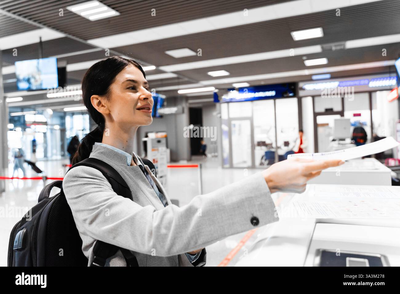 Woman giving boarding pass and passport at the airport check in counter ...