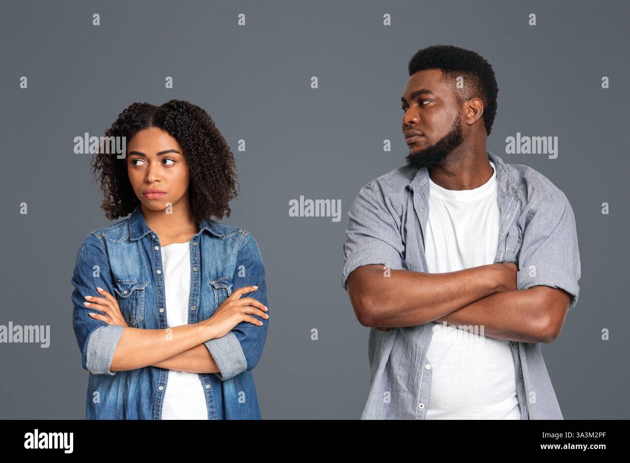 A couple stands apart with crossed arms, expressing feelings in a ...