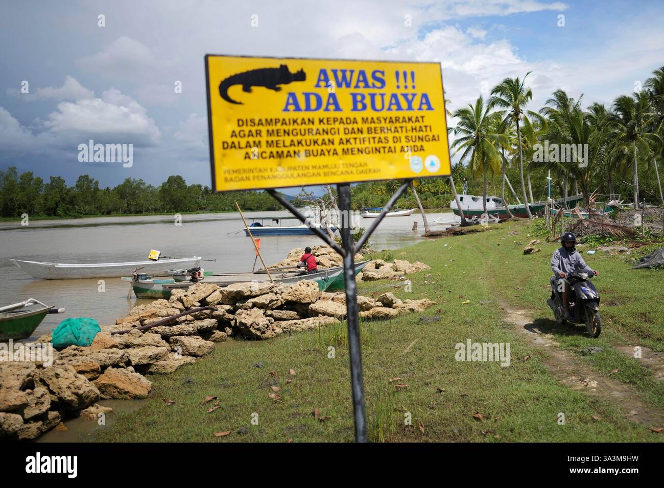 A crocodile warning sign is displayed by the river in Budong-Budong ...