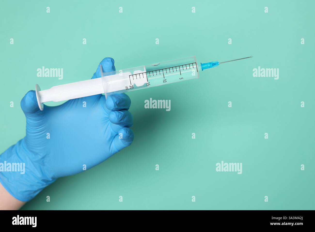 Doctor holding syringe with medication on turquoise background, closeup ...