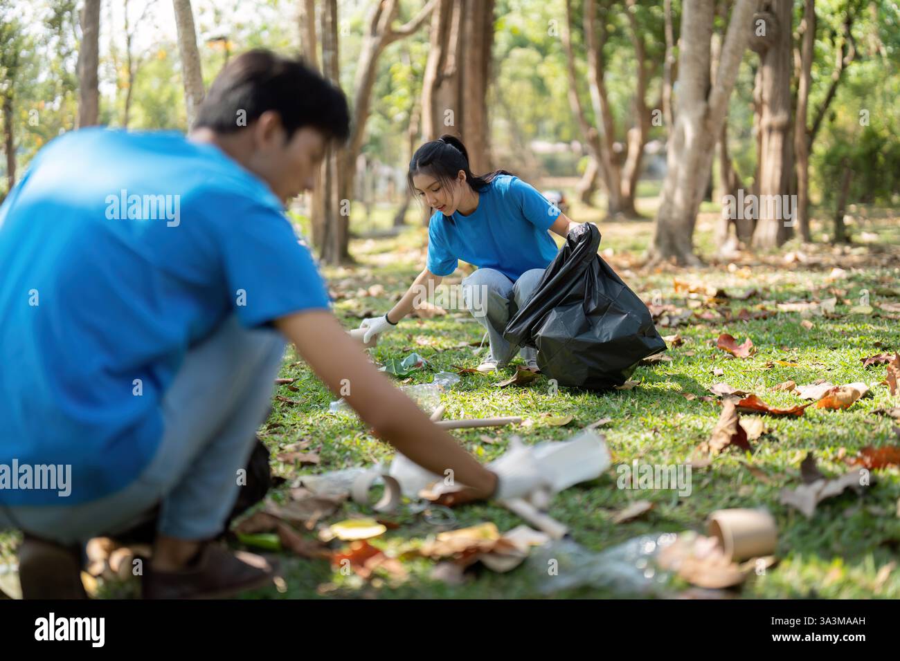 Sustainability and Volunteer Work. Two young volunteers cleaning up a ...