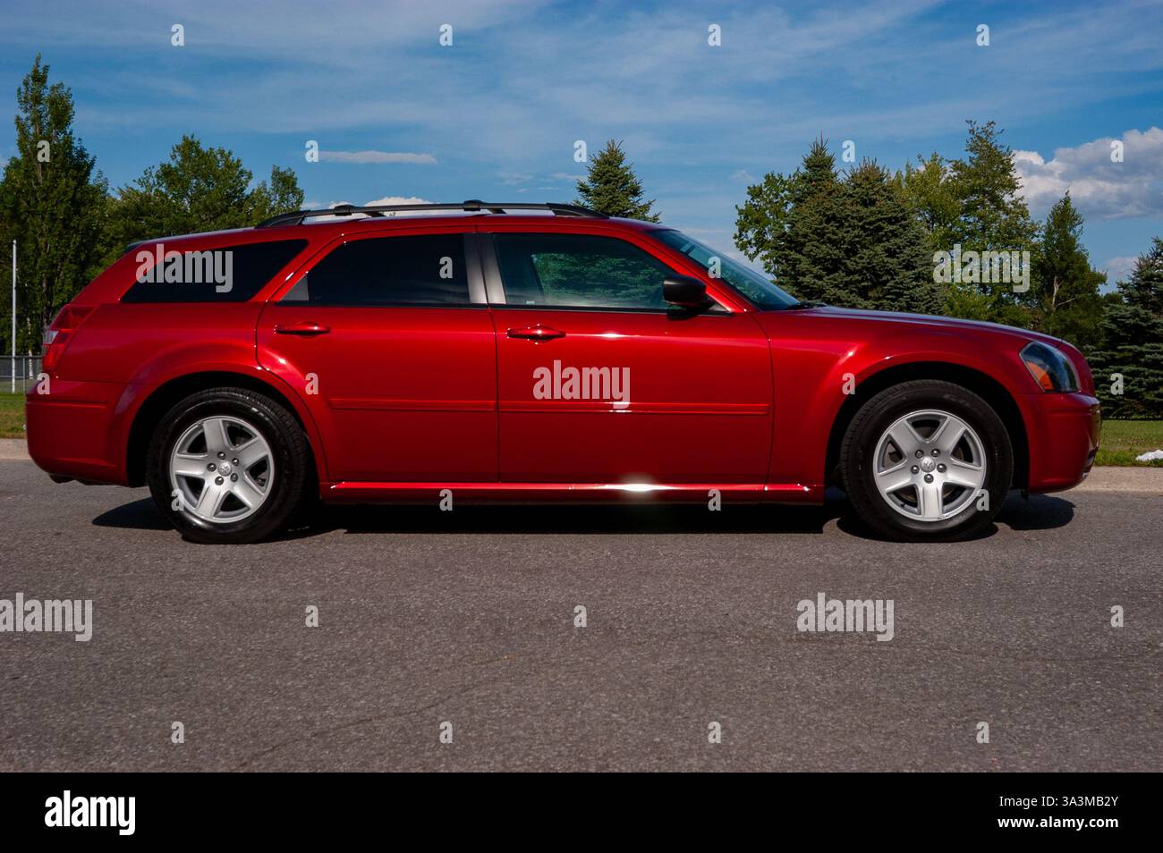 Side view of a red Dodge Magnum with a park in the background Stock ...