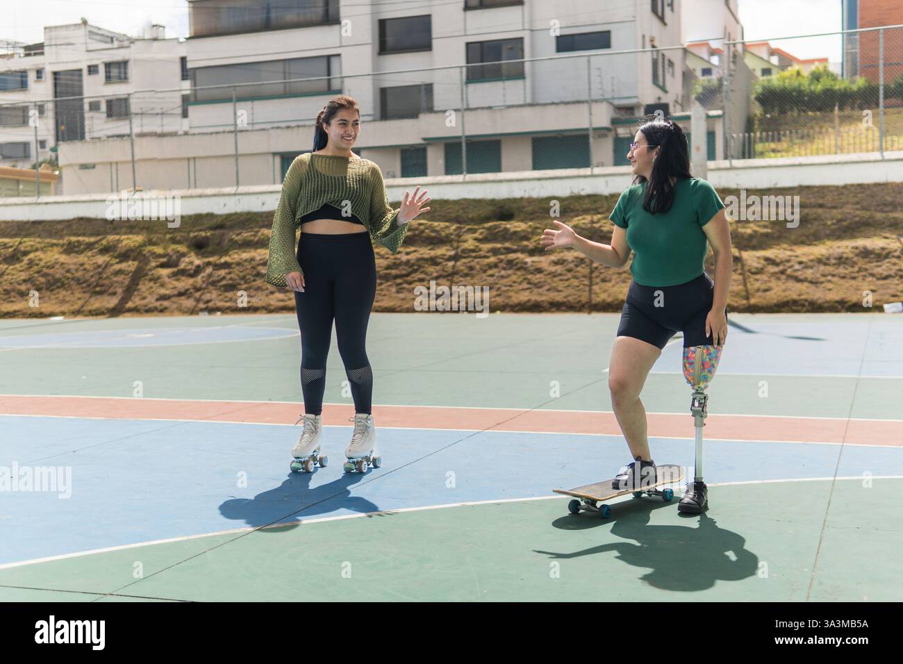 Two female friends, one with a prosthetic leg, practicing roller ...