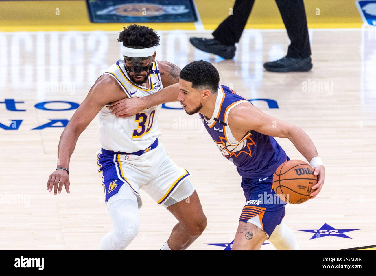 Phoenix Suns' Devin Booker #1 drives against Los Angeles Lakers' Jordan Goodwin #30 during an ...