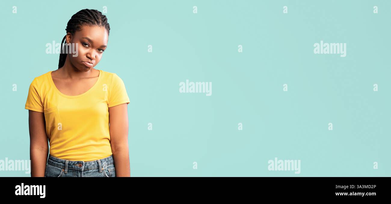 Young woman expressing disappointment against a light blue background ...