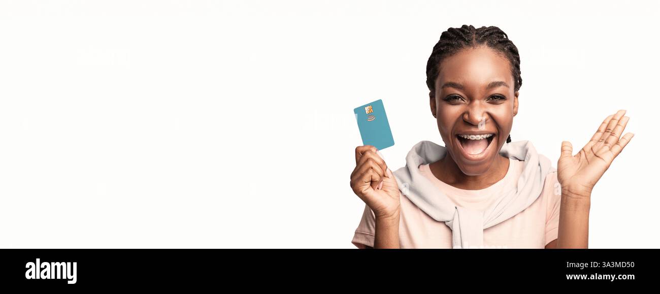 Happy woman celebrating with a card in hand against a plain background ...