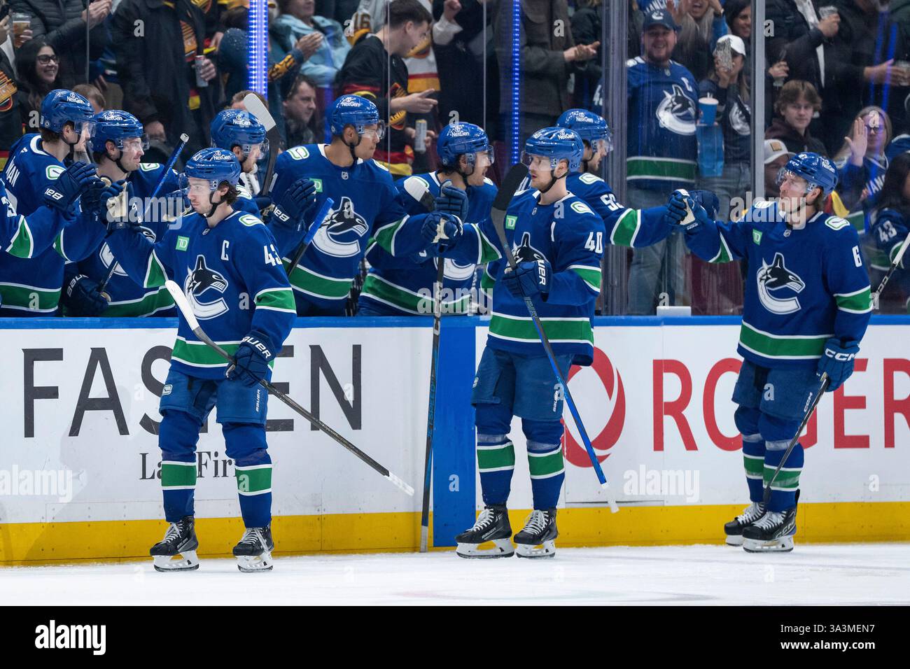 Vancouver Canucks' Quinn Hughes (43), Elias Pettersson (40) and Brock Boeser (6) celebrate ...