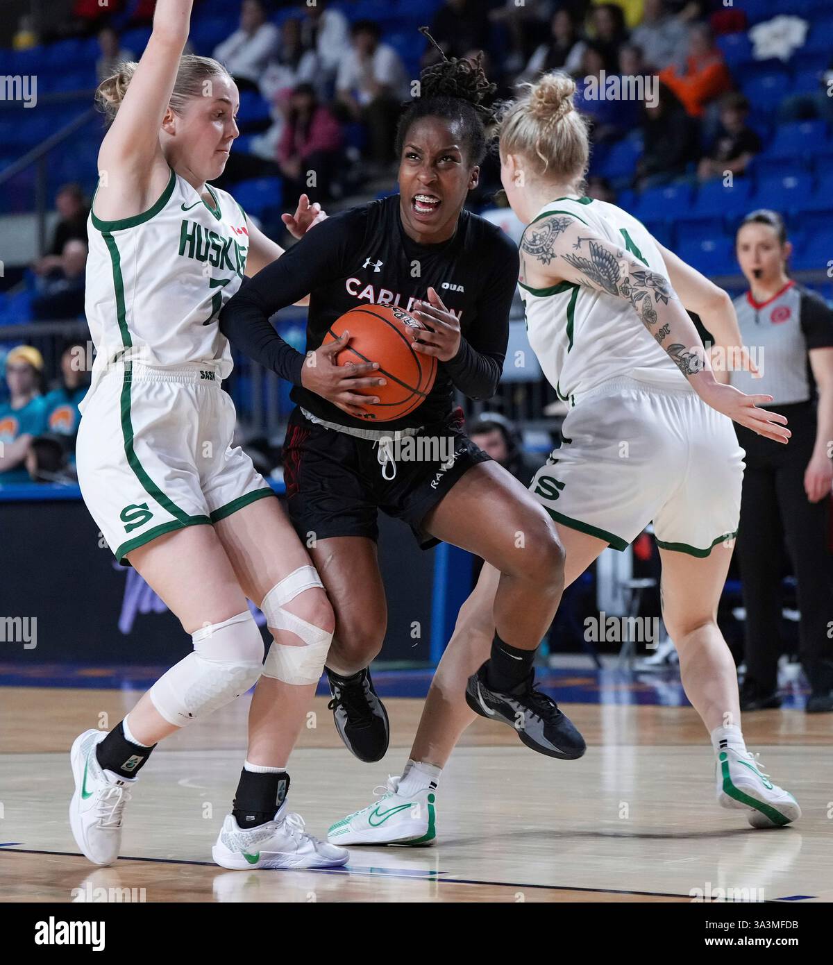 Carleton's Dorcas Buisa, center, tries to drive past University of ...