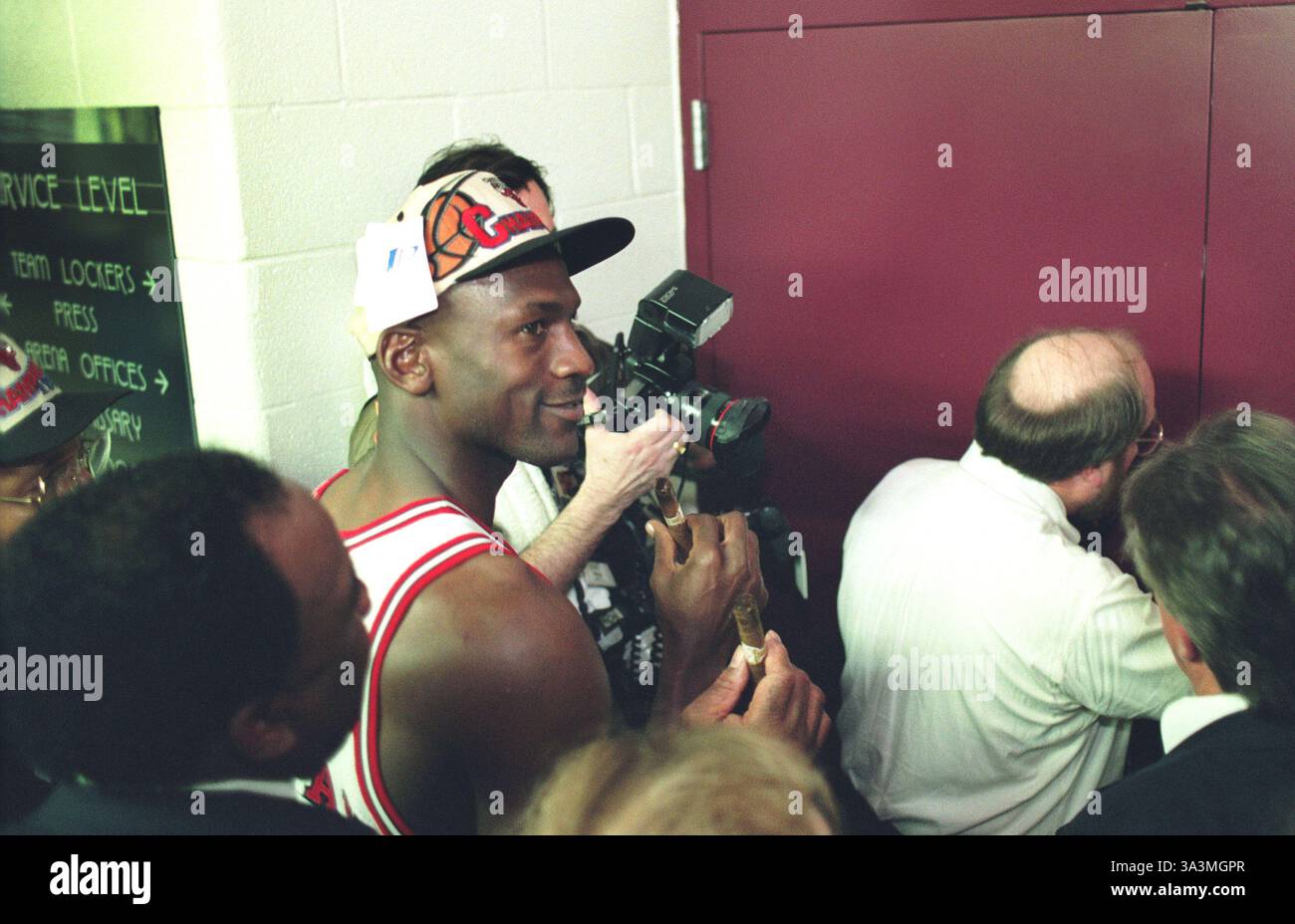 Cigar in hand, Chicago Bulls Star Michael Jordan heads to the locker ...