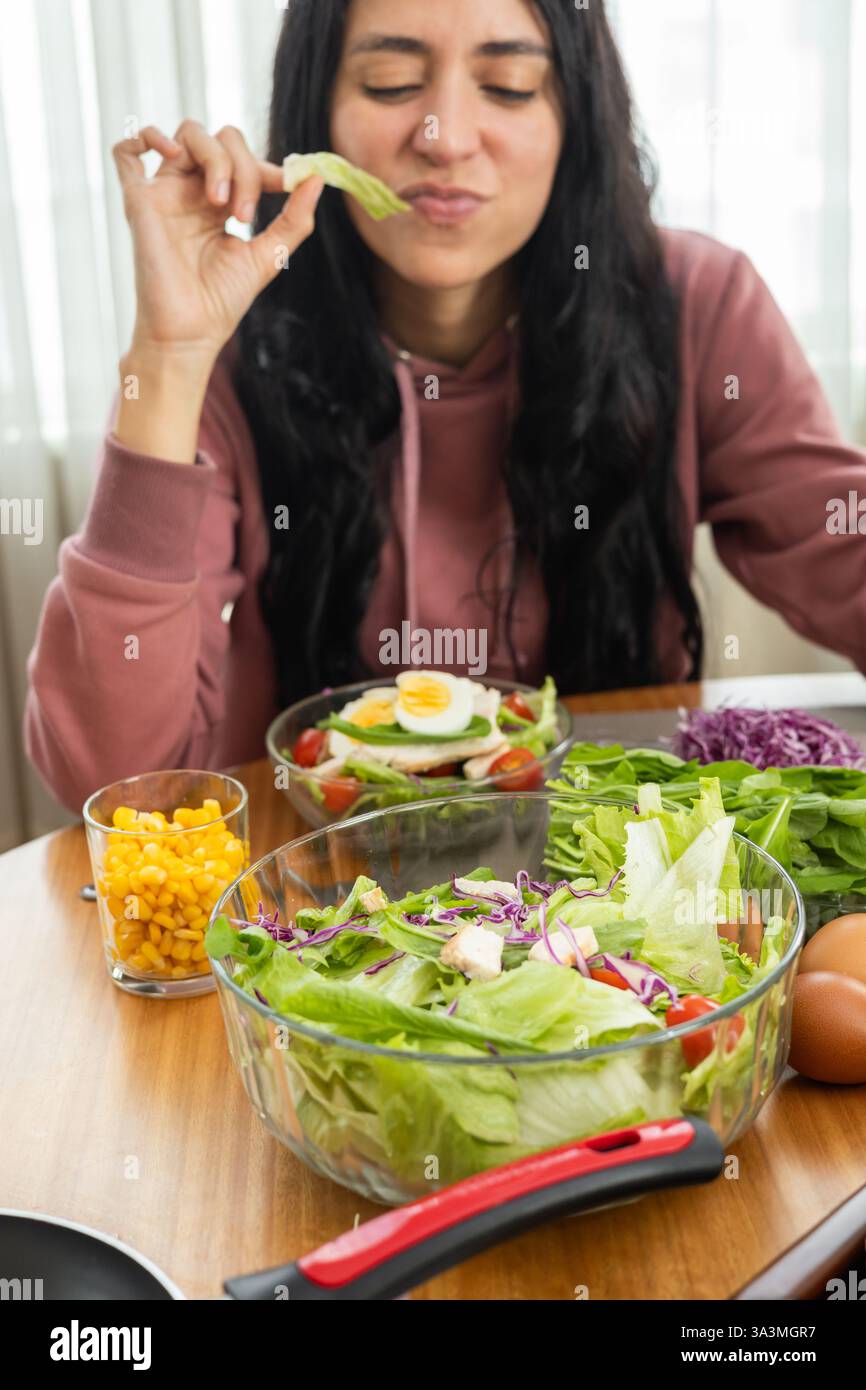 A woman blissfully enjoying a fresh salad with tomato, lettuce, and ...