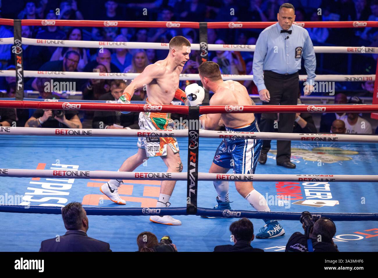 Callum Walsh of Ireland (orange and silver trunks) knocks out Dean Sutherland of Scotland (blue ...